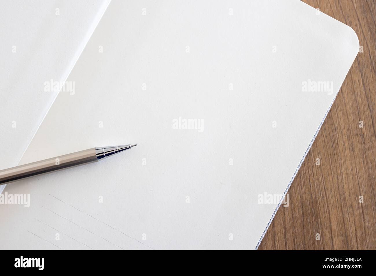 top view of blank open notebook page and pencil on wood table ...