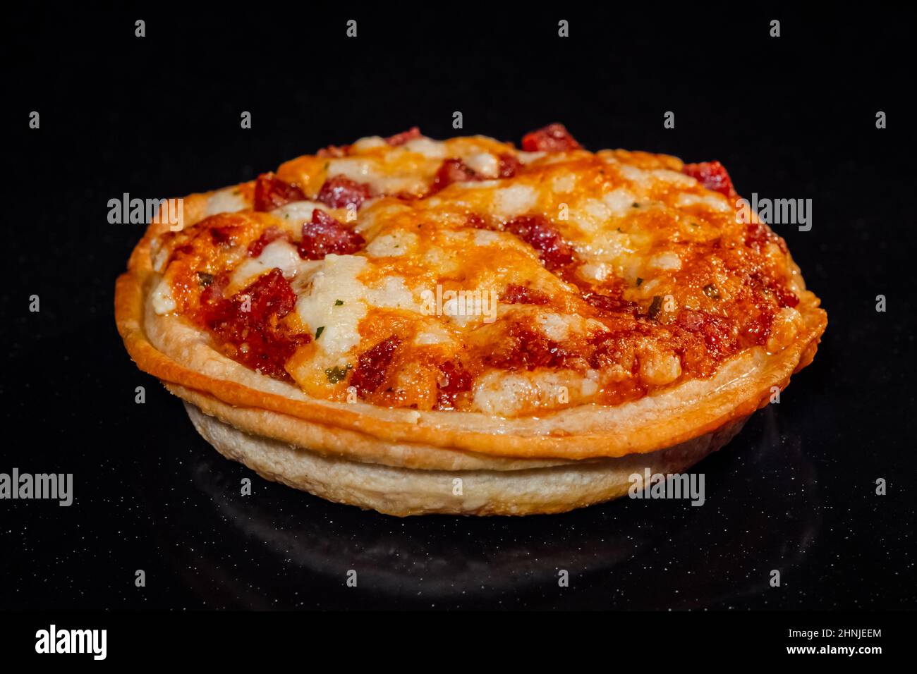 Baked homemade mini pizza in electric oven at home, black background Stock Photo - Alamy