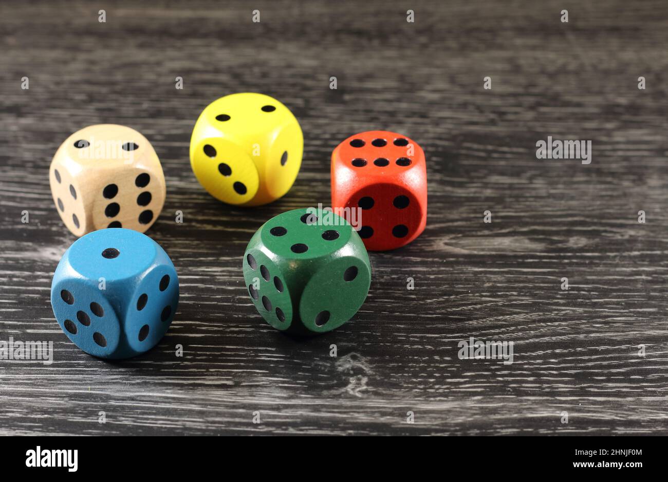 colorful five dice games on a black table Stock Photo - Alamy