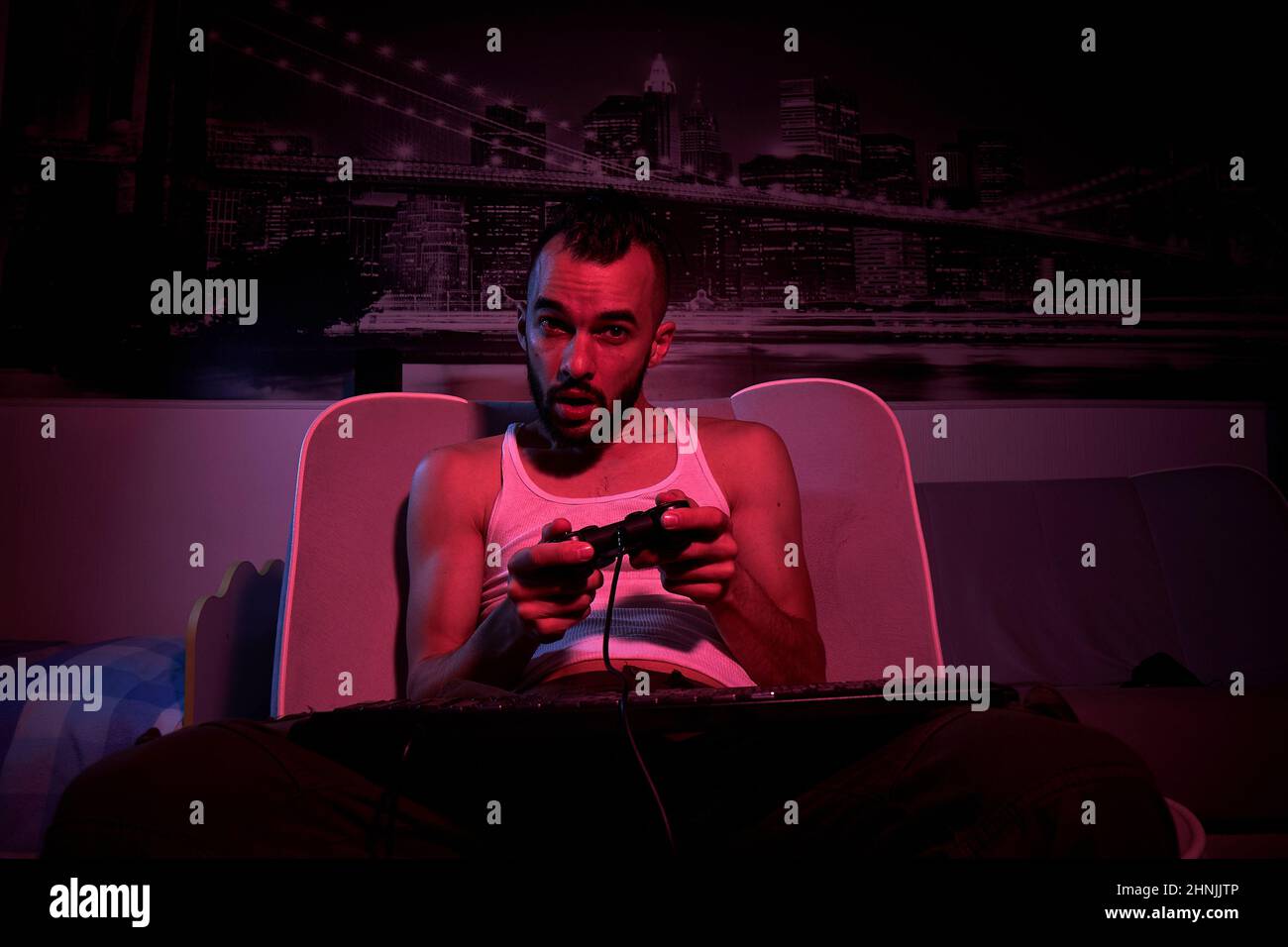 a thirty-year-old guy with a joystick in his hands is playing computer ...