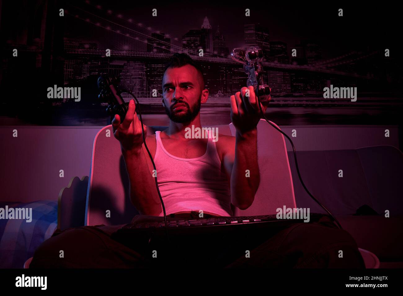 a thirty-year-old guy with a joystick in his hands plays computer games ...
