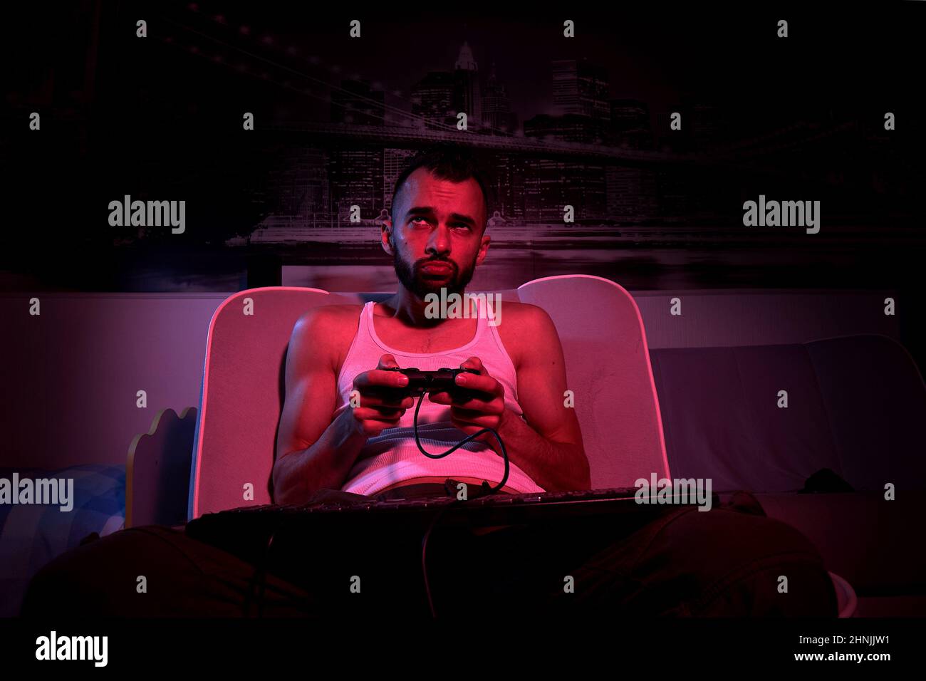 a thirty-year-old guy with a joystick in his hands is playing computer ...