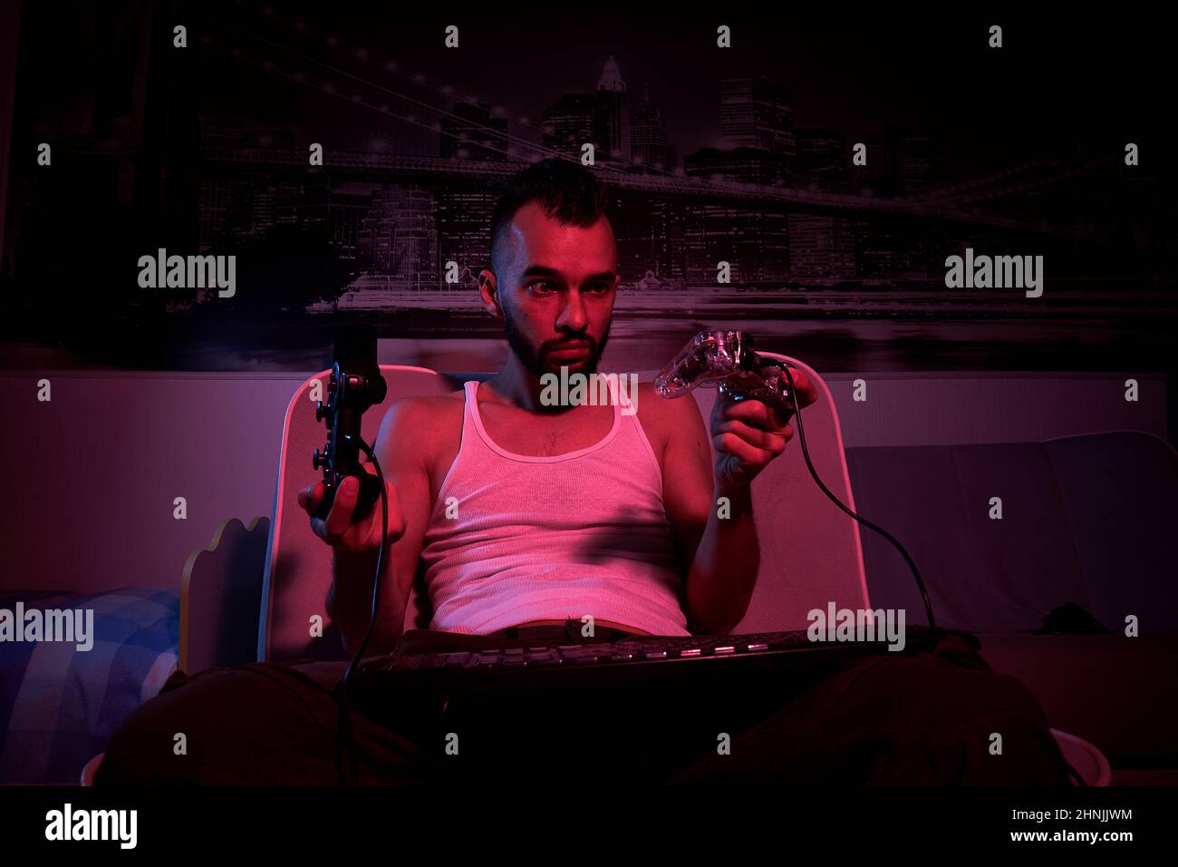 a thirty-year-old guy with a joystick in his hands plays computer games ...