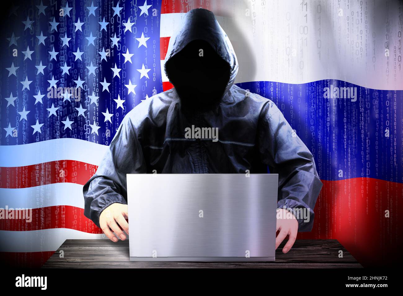 Anonymous hacker working on a laptop, flags of USA and Russia Stock ...