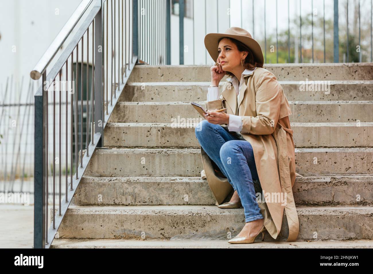 Woman taking notes and writing ideas in a notepad while sitting on the ...