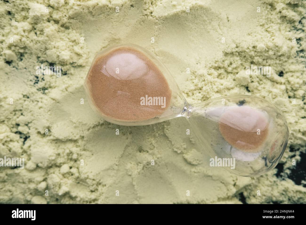 hourglass on table, sand flowing through the bulb of sandglass Stock ...