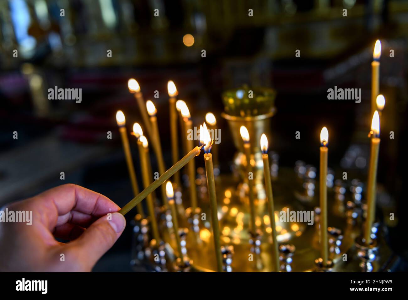 Candles in Russian orthodox cathedral with icons on background. Hand ...