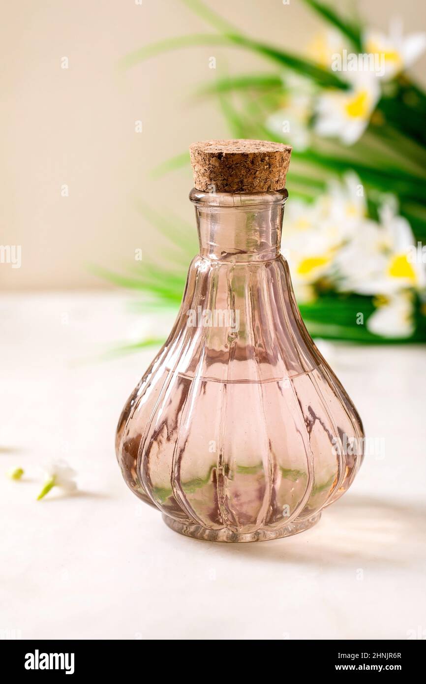 Beautiful pink transparent bottle of perfume with cork, standing on ...