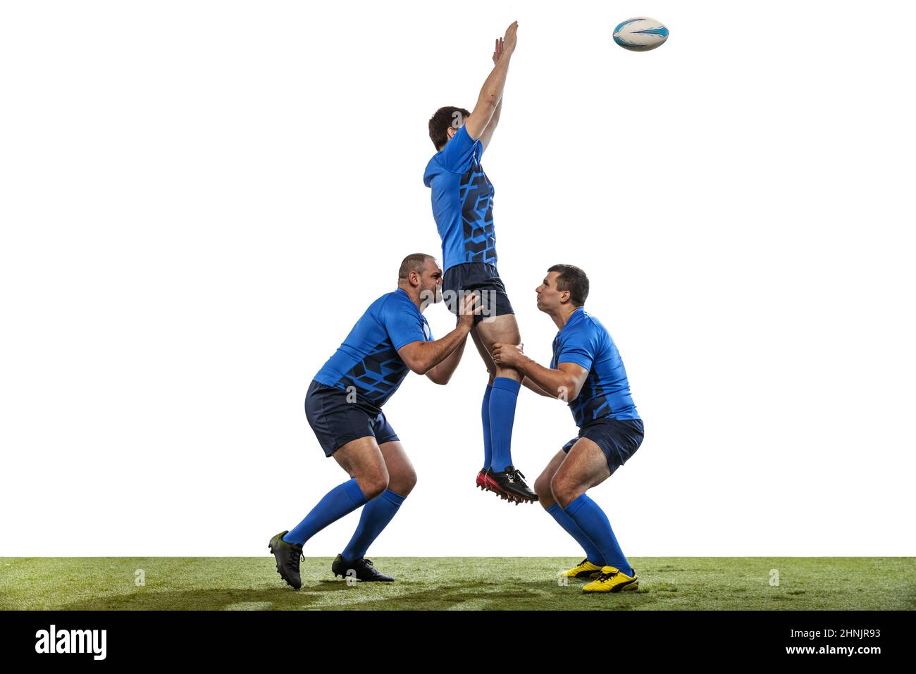 Dynamic portrait of male rugby players playing rugby football on grass ...