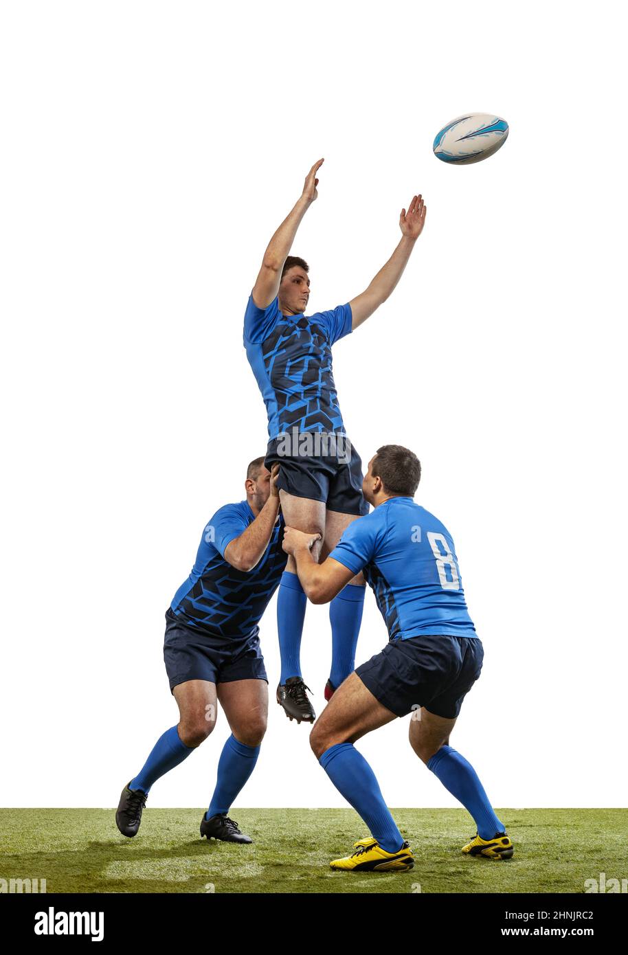 Three male rugby players playing rugby football on grass field isolated ...