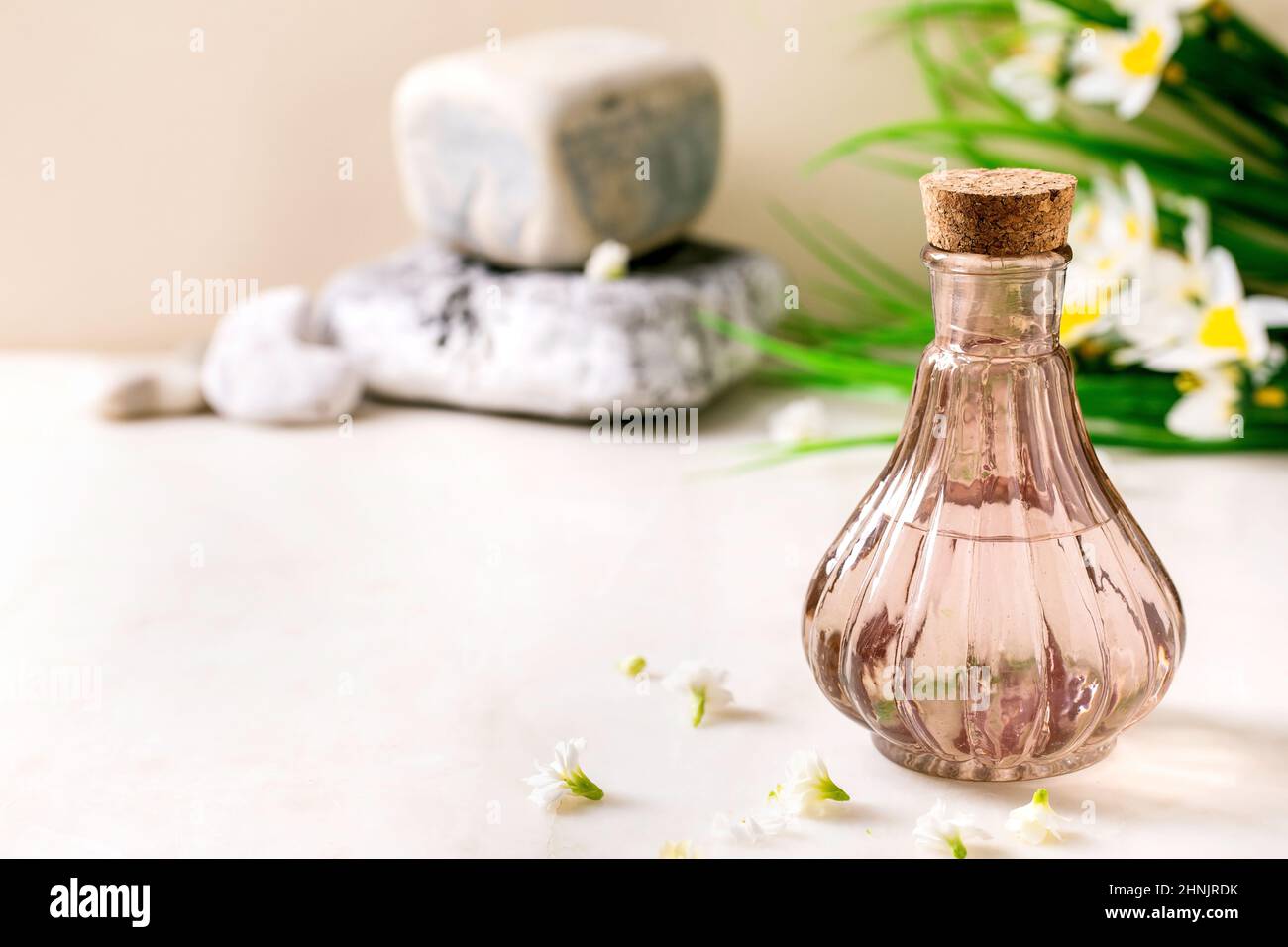 Beautiful pink transparent bottle of perfume with cork, standing with ...