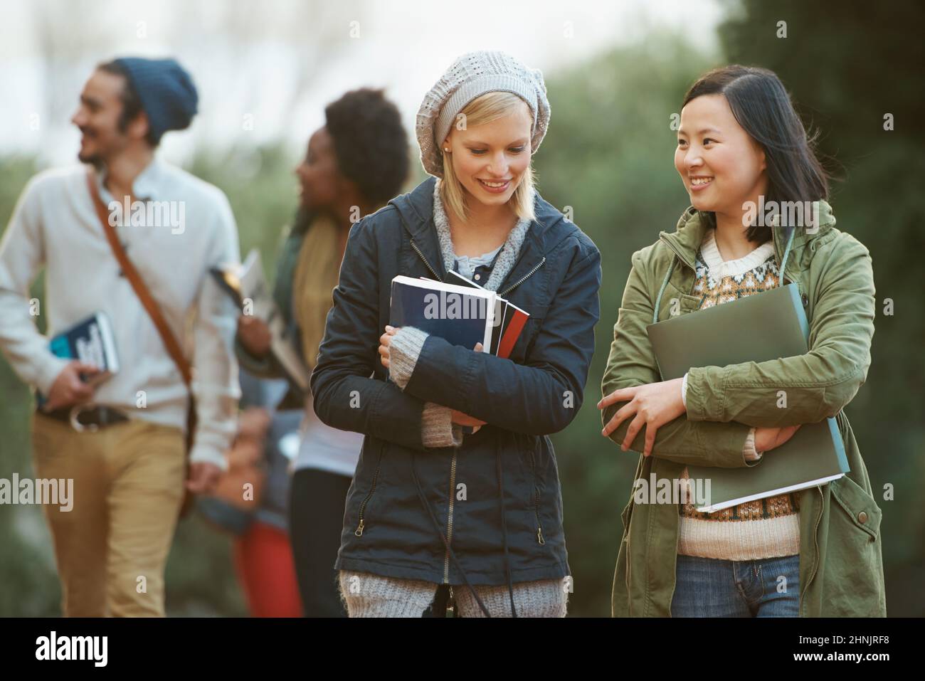 College life. Shot of a college students between classes on the campus ...