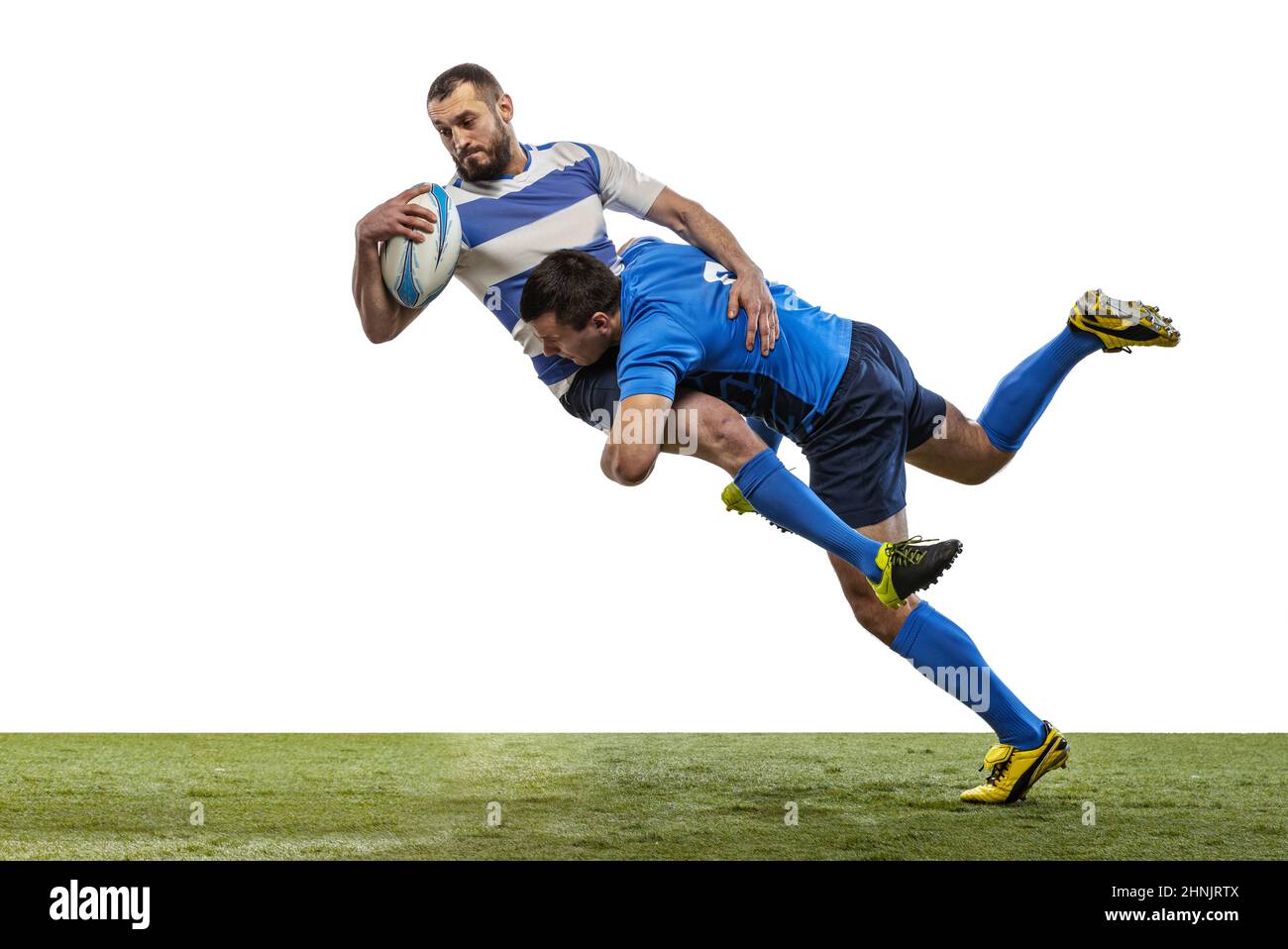 Dynamic portrait of male rugby players playing rugby football on grass ...