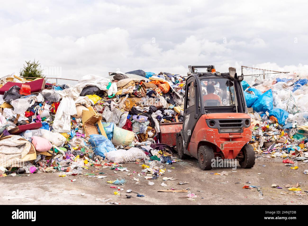A bulldozer tractor pushes garbage in a city dump. Waste management ...