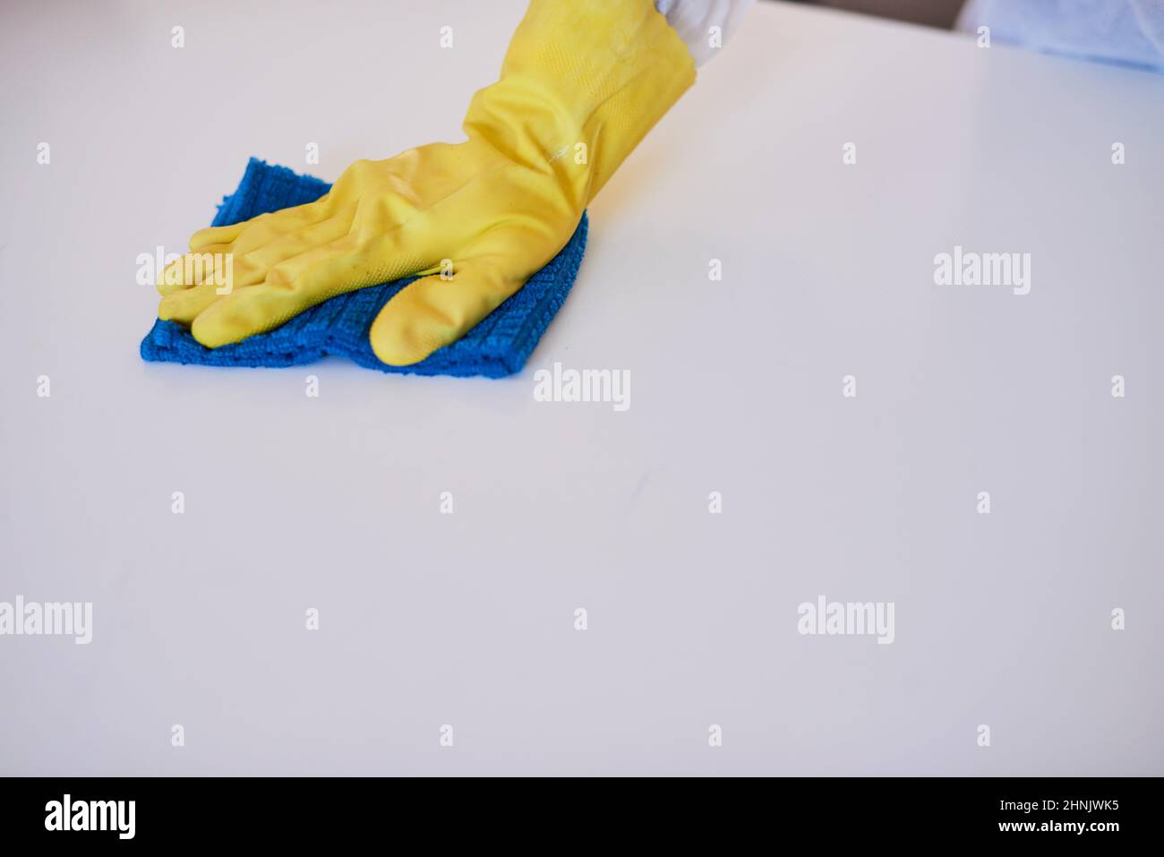 A cleaning professional wipes a kitchen counter wearing gloves Stock ...