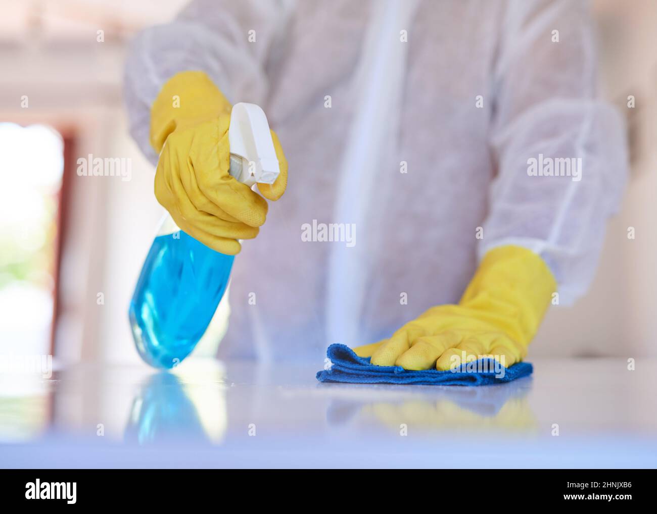 A cleaning professional sprays a kitchen counter with sanitiser Stock ...