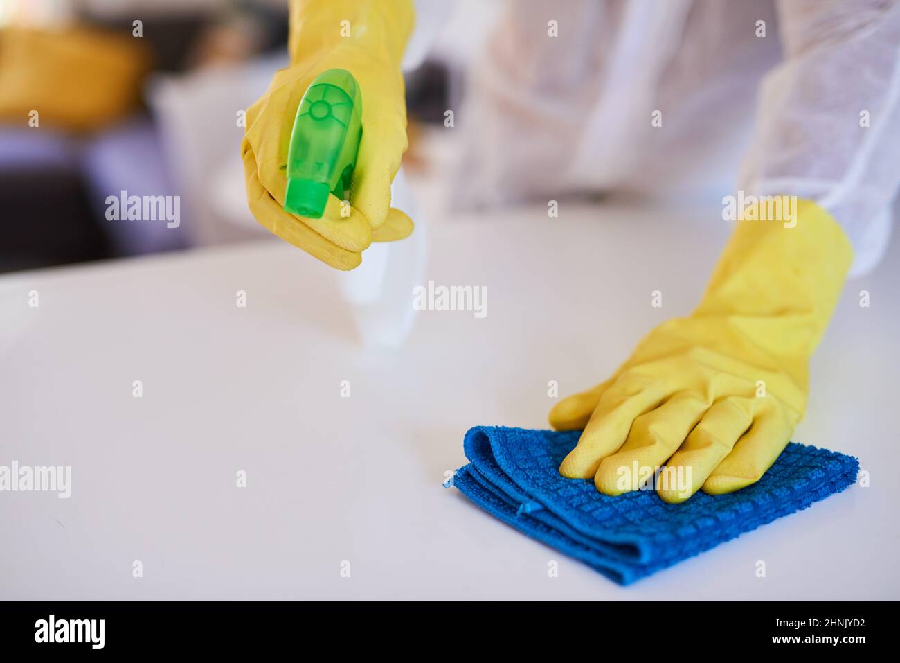 A cleaning professional sprays a kitchen counter with sanitiser Stock ...