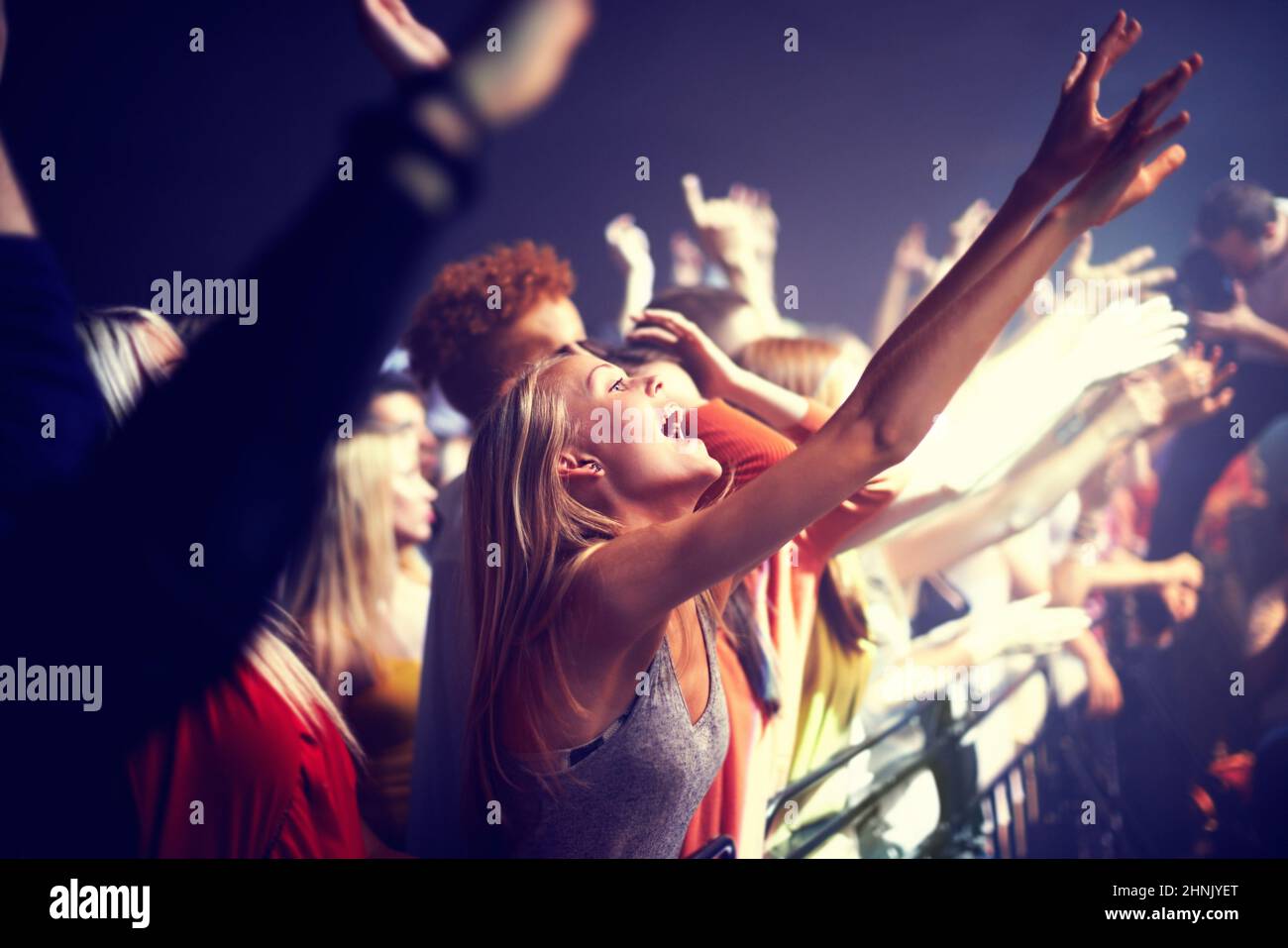 Enjoying the music. A group of people standing with their arms raised ...