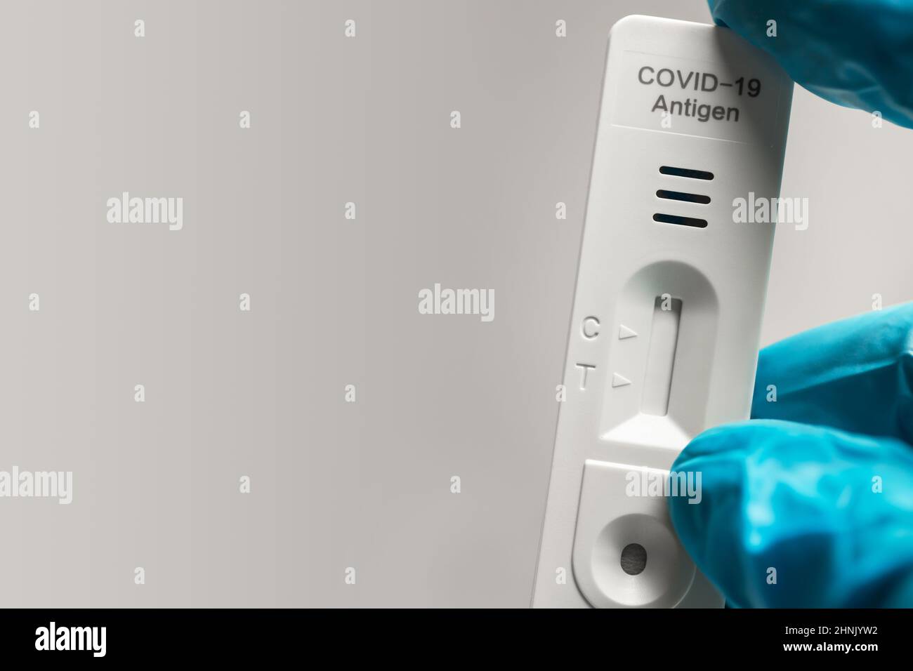 a covid-19 antigen rapid test in a hand with a medical glove and a big ...