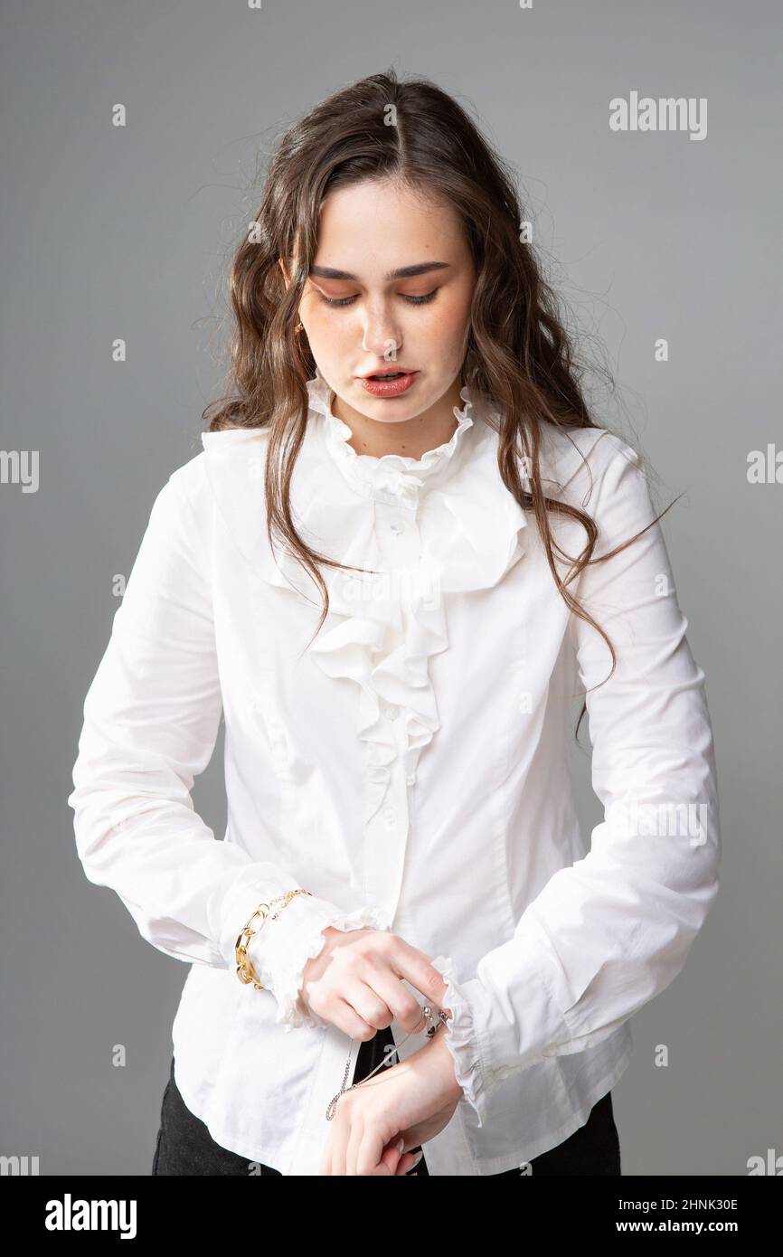 Speaking shy young woman with long hair in white long sleeve blouse ...