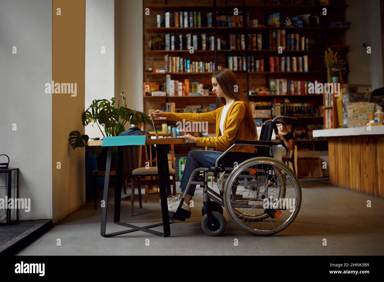 Disabled female student in wheelchair using laptop, disability ...