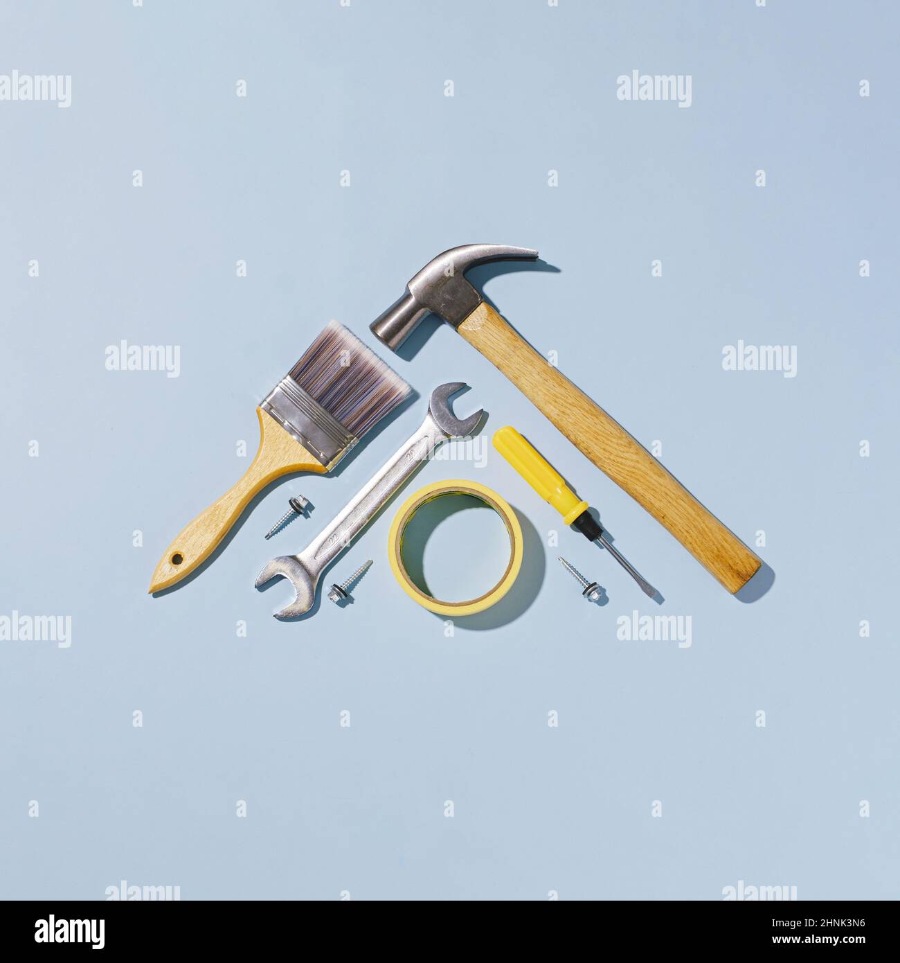 Triangular arrangement of hand tools over a blue background in a top ...