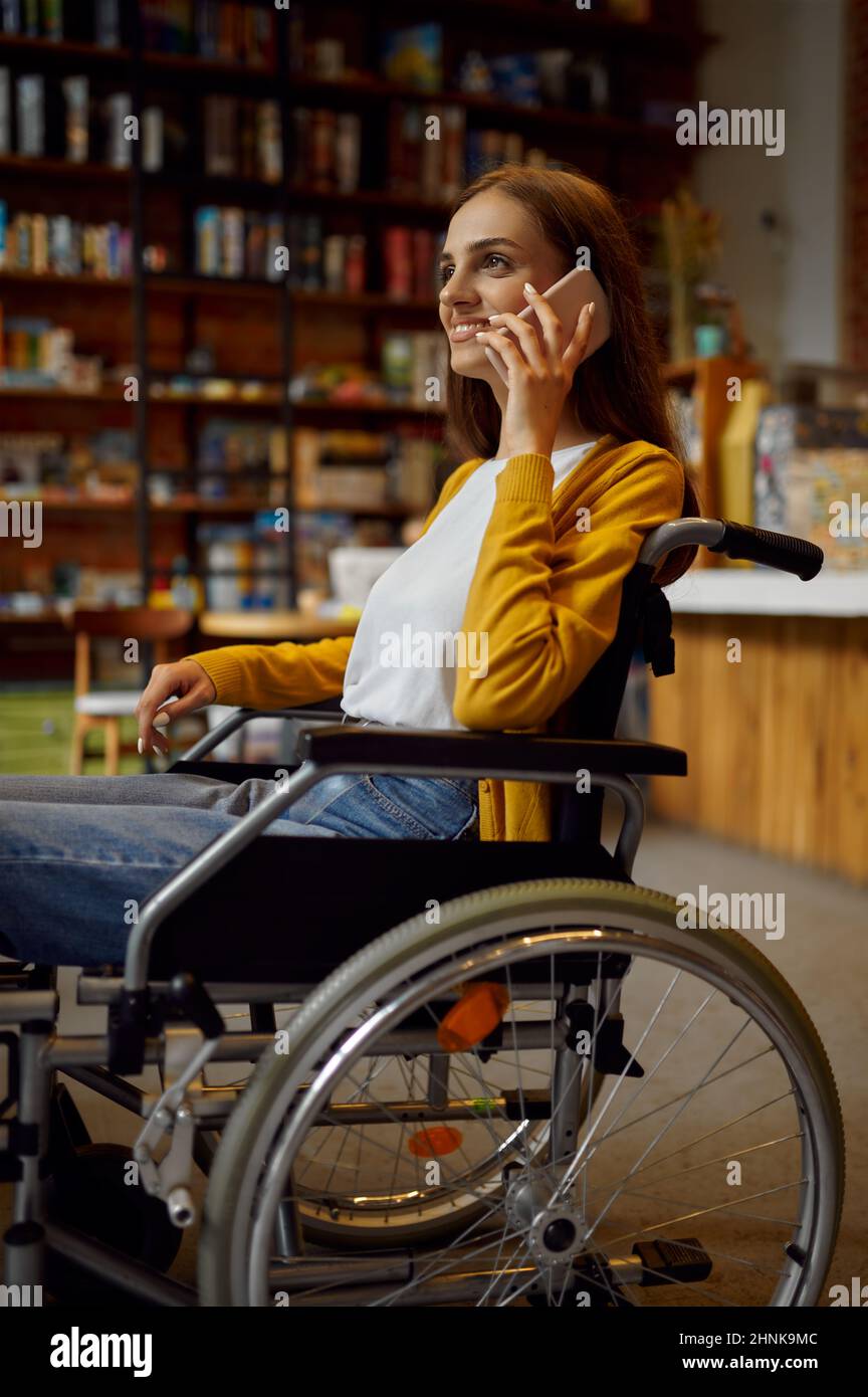 Disabled female student in wheelchair using phone, disability ...