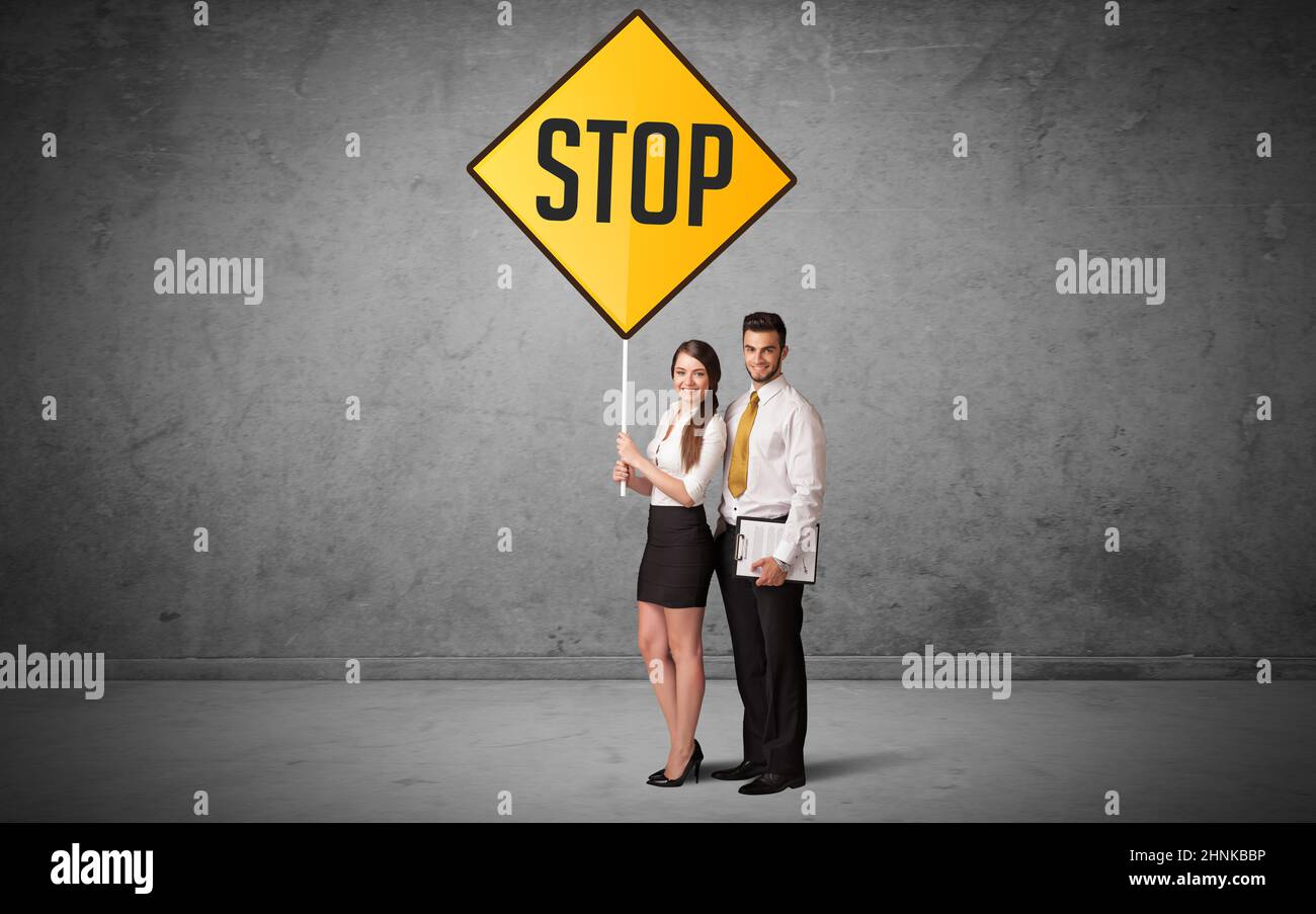 Young business person holding road sign Stock Photo - Alamy