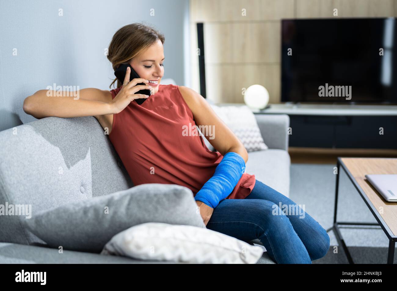 Injured Woman Talking On Phone At Home After Accident Stock Photo - Alamy