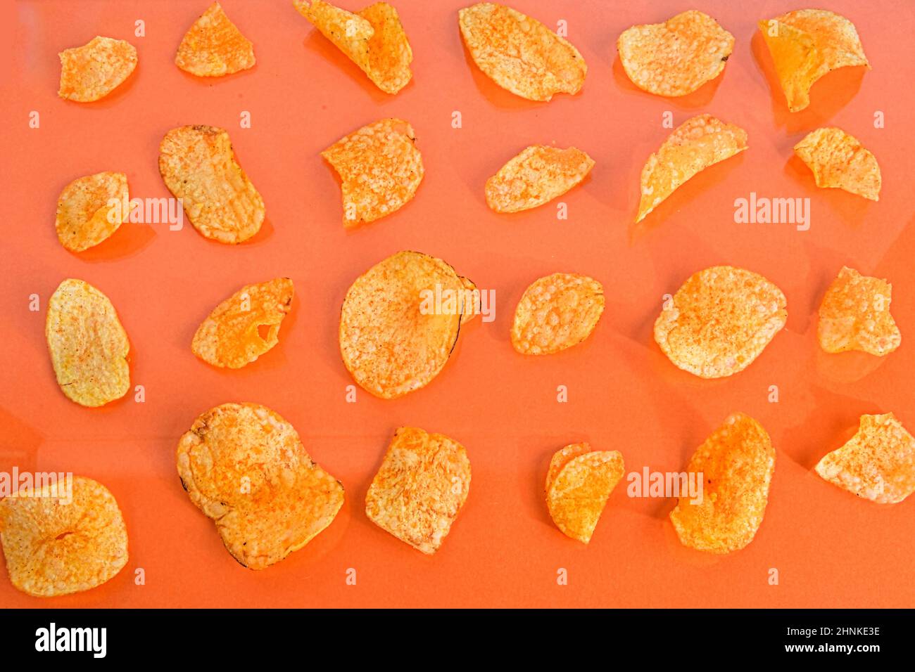 Potato chips or crisps on orange background. Movie background. Top view ...