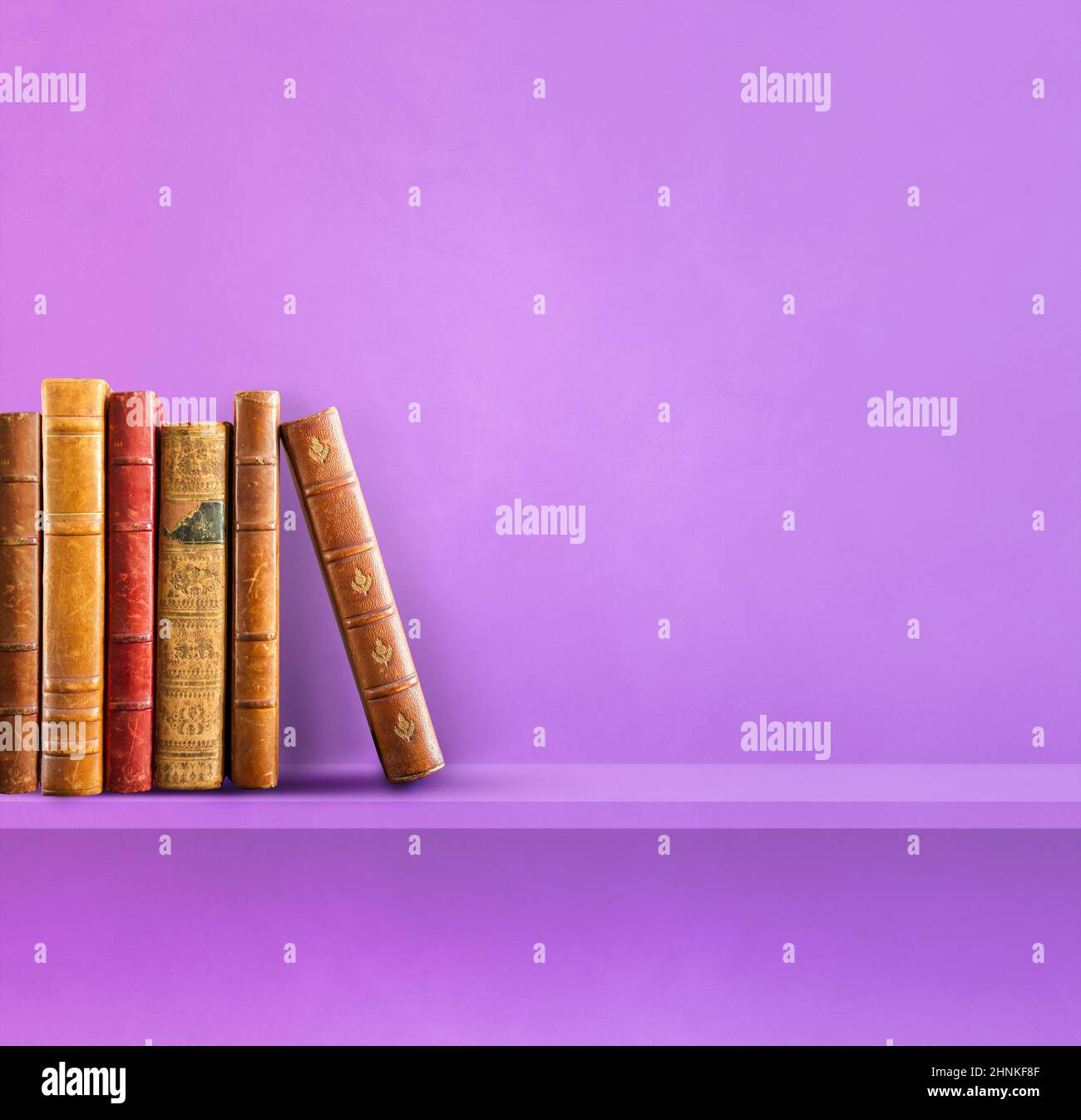 Row of old books on purple shelf. Square background Stock Photo - Alamy