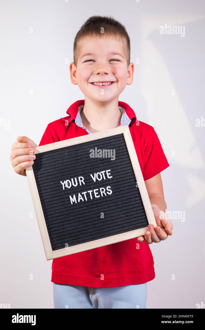 kid boy holding letter board with text Your Vote Matters on white ...