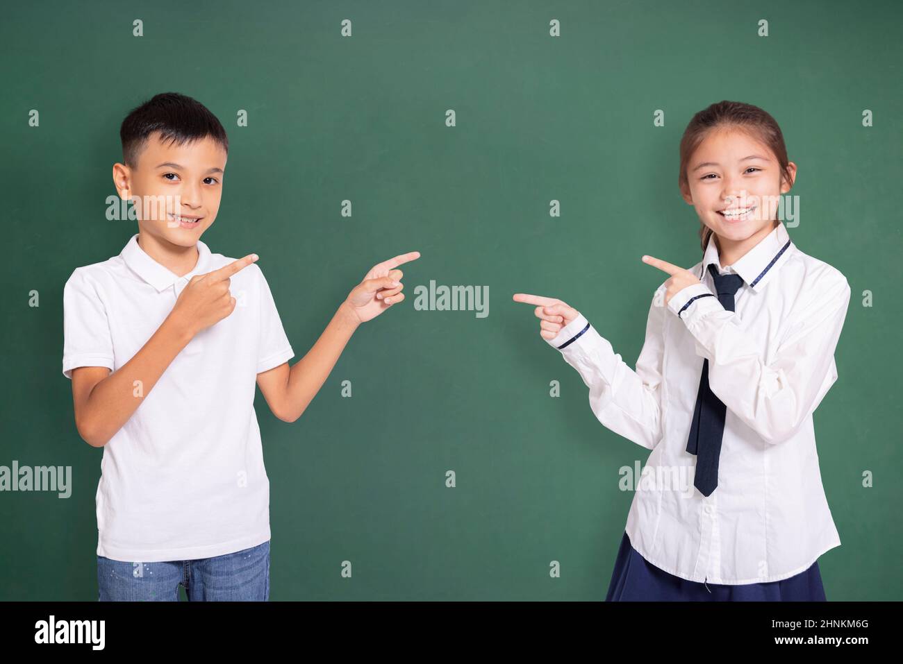Happy student boy and girl pointing at each other Stock Photo - Alamy