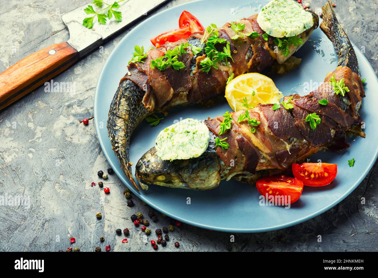 Baked fish wrapped in bacon, fried pelengas Stock Photo - Alamy