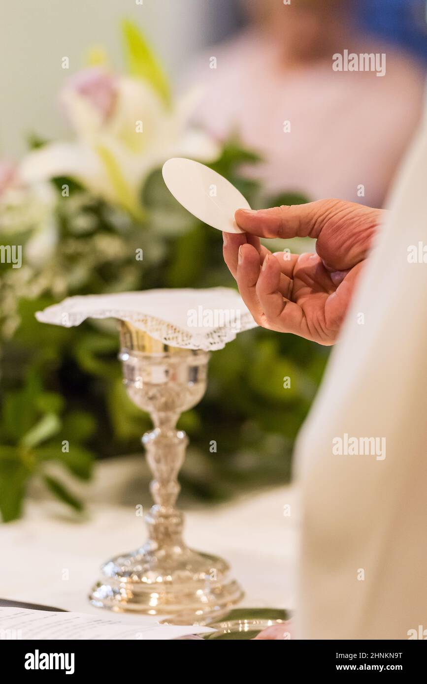 During the christian mass a priest celebrates the rite of the communion ...