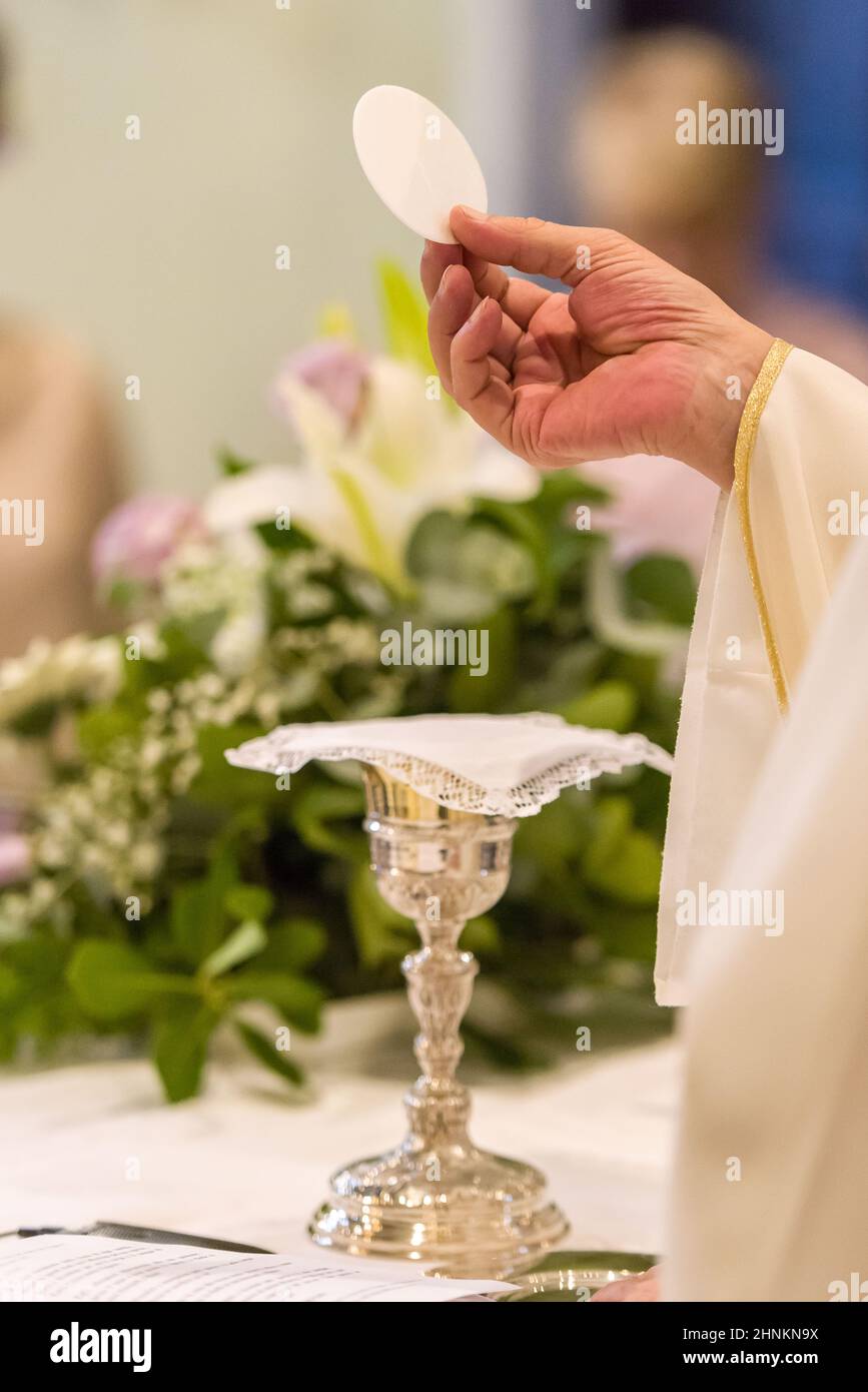 During the christian mass a priest celebrates the rite of the communion ...