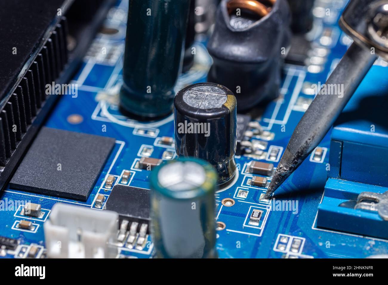 The hand holding the tin, a soldering iron solder the chip in place ...