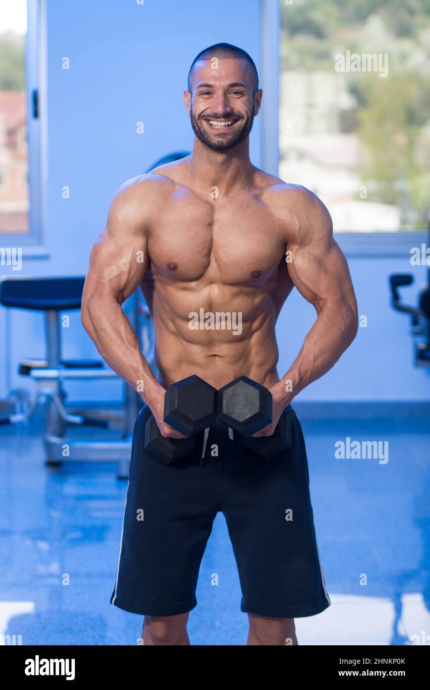 Bodybuilder Exercising Shoulders With Dumbbells Stock Photo - Alamy