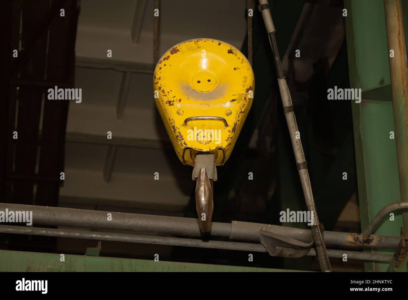 Industrial yellow crane hook hanging in the factory Stock Photo - Alamy