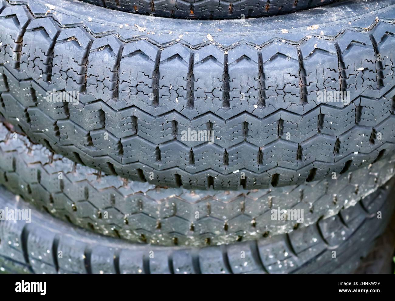Damaged and worn old black tires on a stack. Damaged and worn old black ...