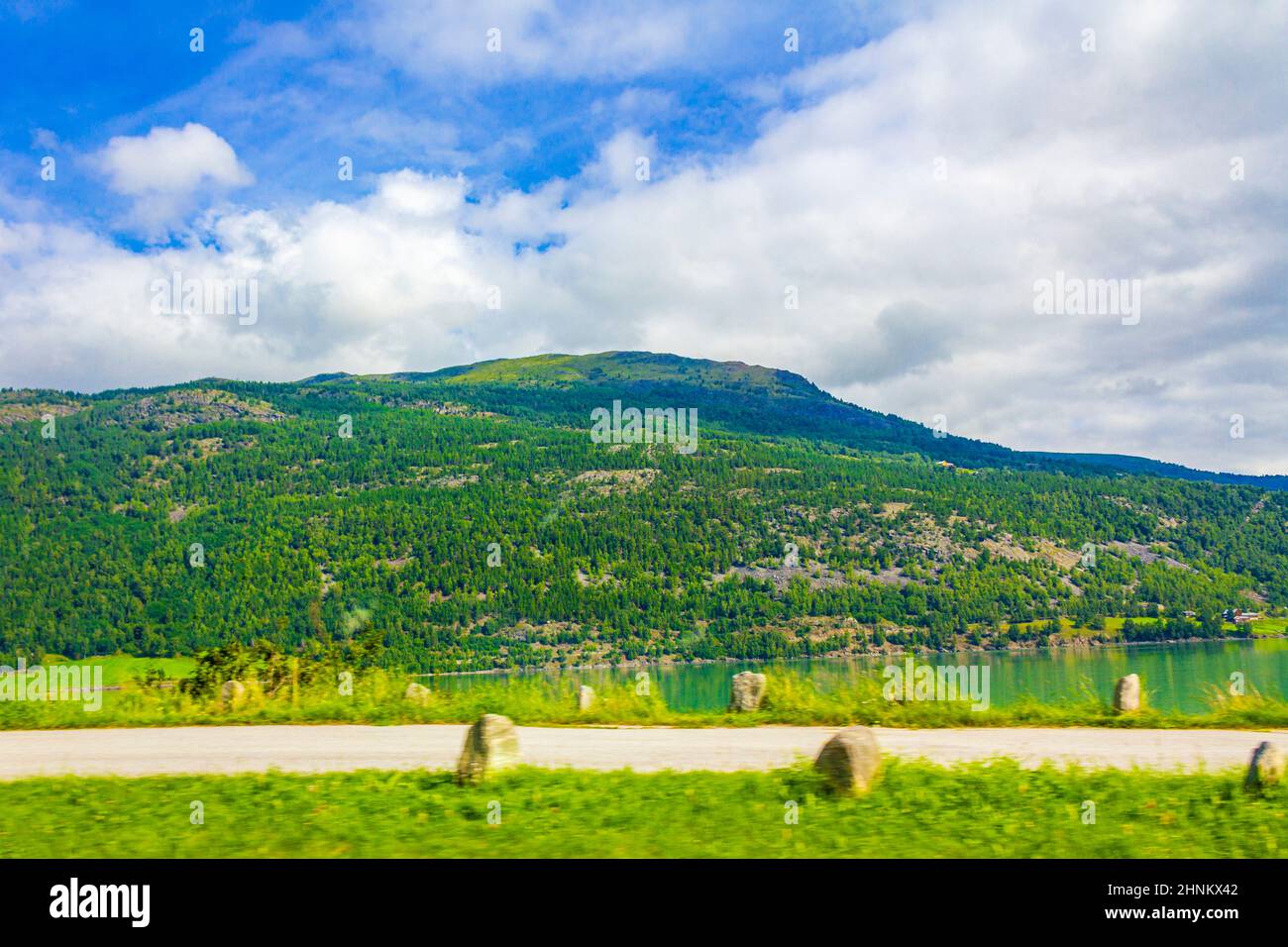 Turquoise green water flows in a fjord river through mountains and ...