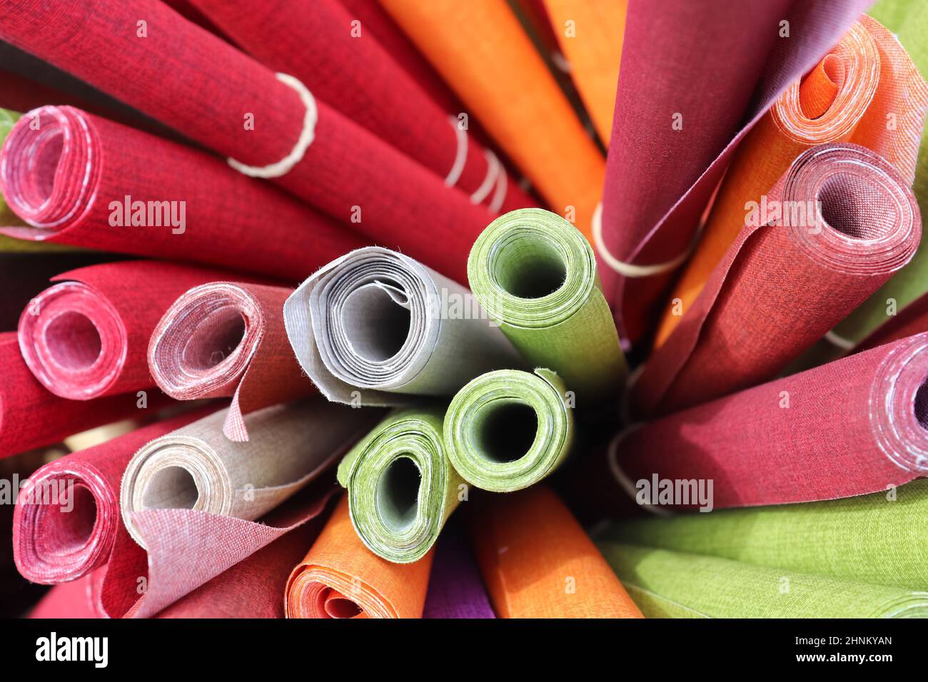 Close up view on rolled samples of cloth and fabrics in different ...