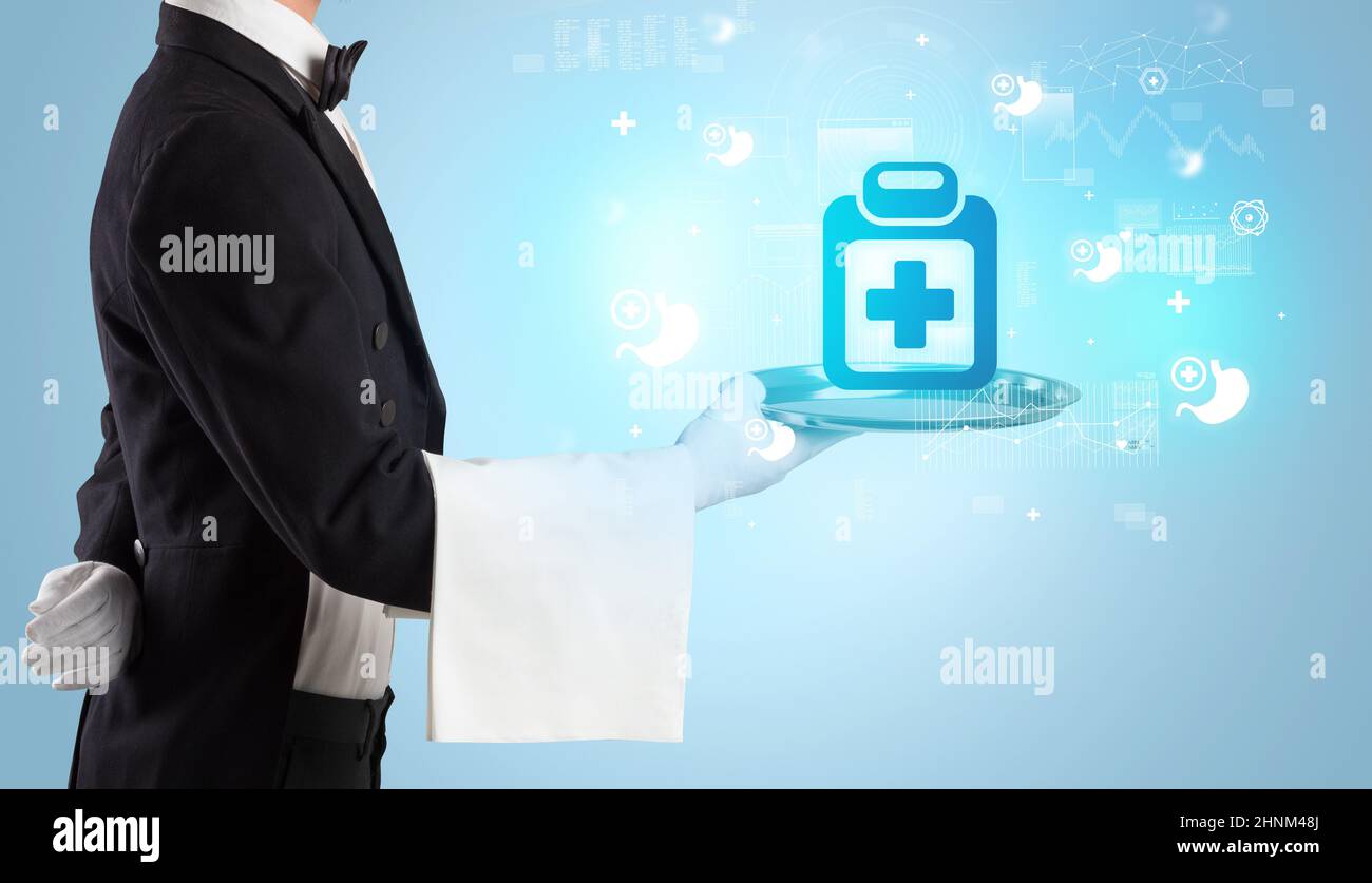 Handsome young waiter in tuxedo holding healthcare icons on tray Stock ...