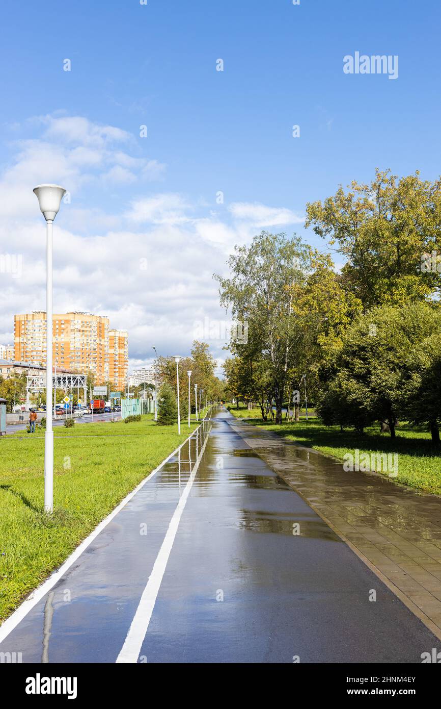 sidewalk with bike path along street after rain Stock Photo - Alamy