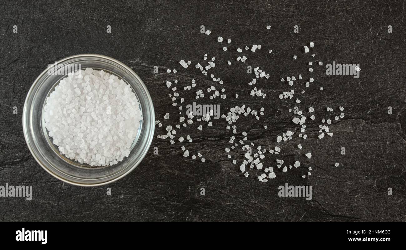 Small glass bowl with white rock salt on black marble like table - some ...