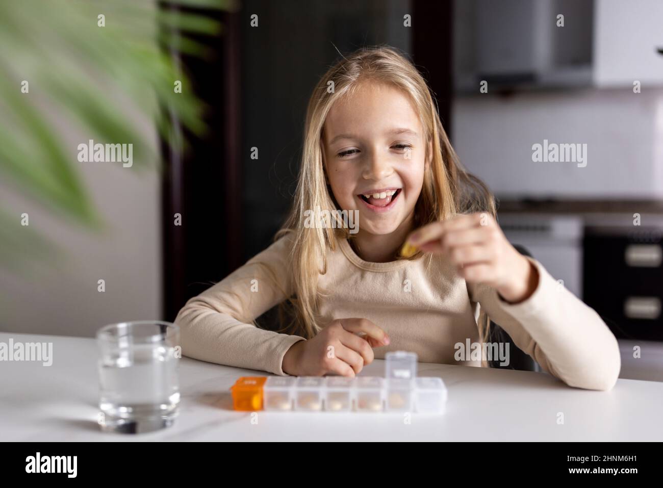 Little Caucasian Girl in pajamas taking natural vitamin omega-3 from ...