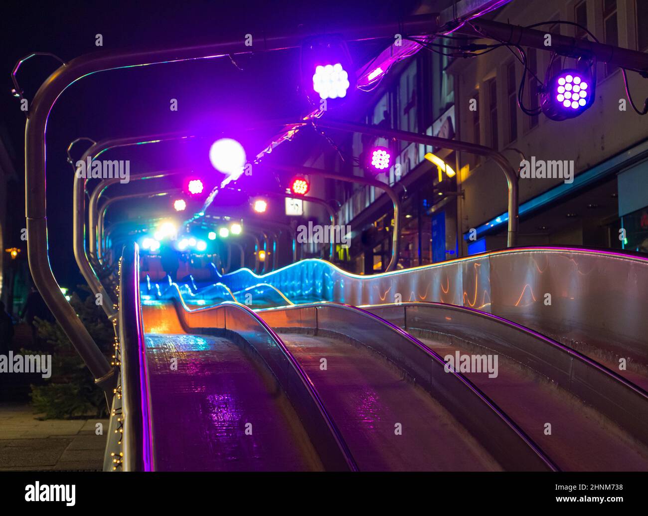 Ice slide illuminated at night with colorful lights Stock Photo - Alamy