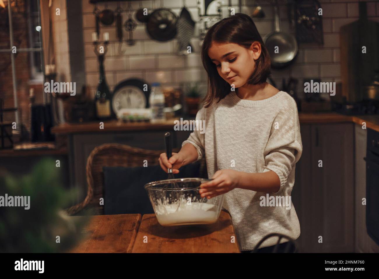 Happy teenage girl cooking in kitchen, smiling little girl standing ...
