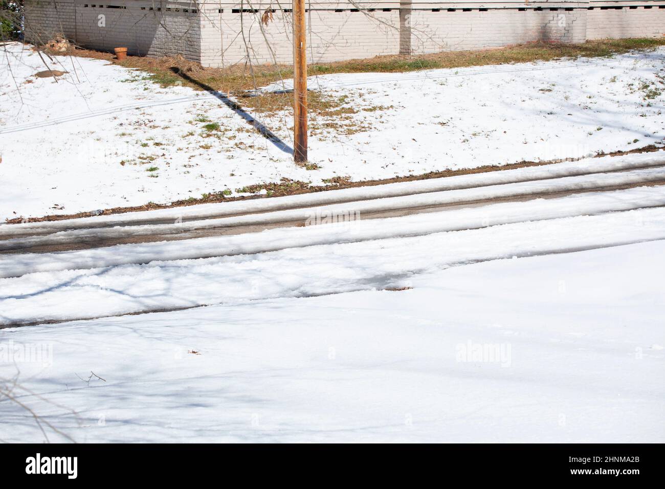 Asphalt tracks showing under a snow-covered, dangerous road Stock Photo ...