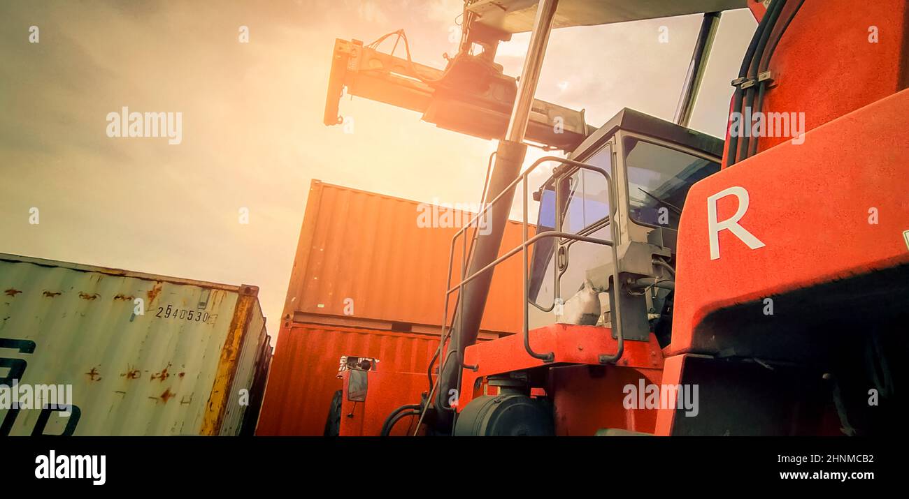 Reach stacker lifting container. Forklift truck handling container at ...